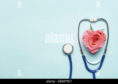 Beautiful rose heart and stethoscope on blue background. Thank you ...