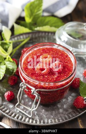Homemade preservation. Delicious raspberries jam or jelly on a rustic ...