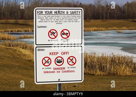 Warning signs around storm drainage pond Stock Photo - Alamy