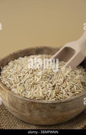 Brown rice in neutral beige background copy space. Whole spelt grain ...
