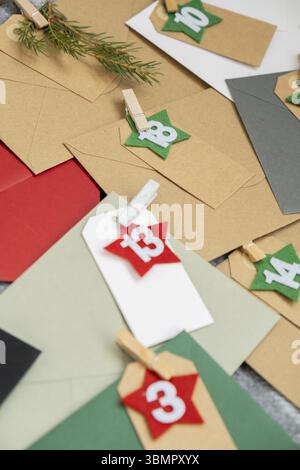 Craft paper envelope. A handmade advent calendar hangs on a tree branch ...