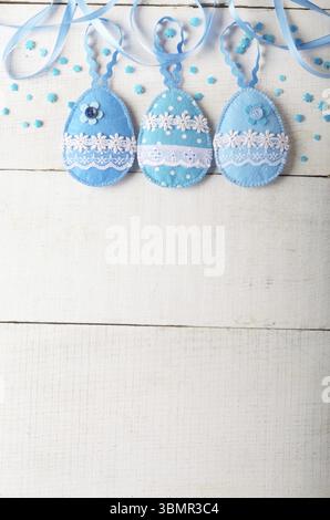 Handmade patchwork blue felt easter eggs on white wooden table Stock ...