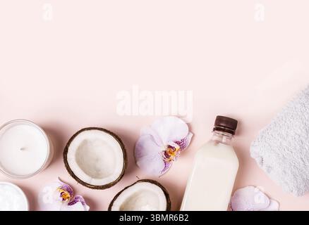 Coconut oil and halves of fresh coconut on a pink background. Hair care ...