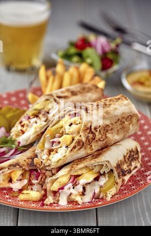 Tasty doner kebab, vegetables and french fries on light background with ...
