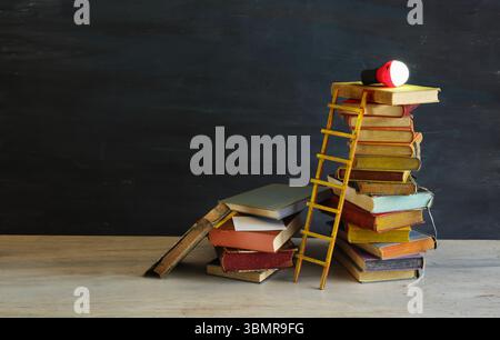 Ladder, books and light bulb on color background Stock Photo - Alamy