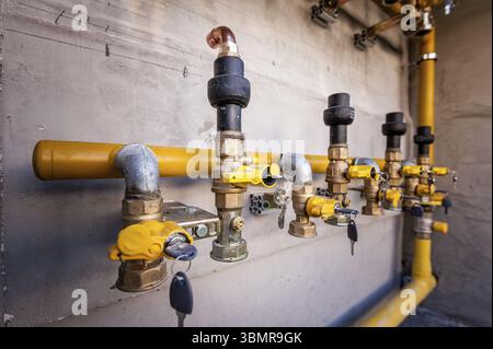 Gas pipe and valve with lock on the wall Stock Photo - Alamy