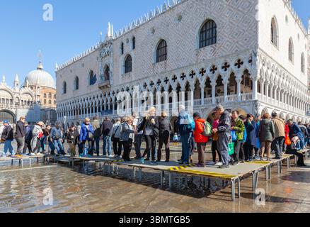 Tourists walking on elevated walkways in San Marco square flooted by ...