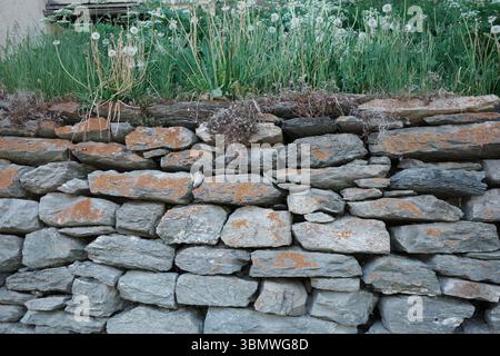 Rough, irregular stone wall composed of variously shaped and sized gray ...