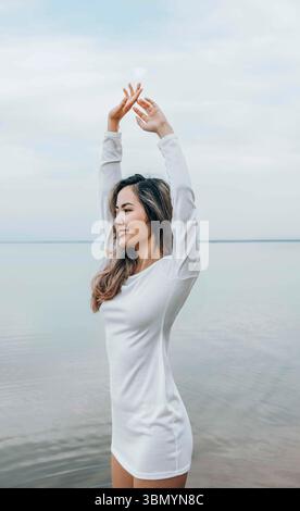 Asian woman stretching arms wearing headphones doing morning exercise ...