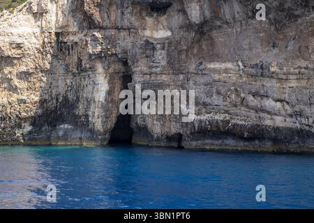 dramatic sea cave, towering cliff, deep blue water, rugged coastline ...