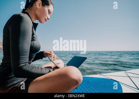 Digital nomad, woman in the hat, a business woman with a laptop sits on ...