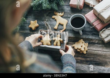 Woman packing gingerbread Christmas cookies in box for present, top ...