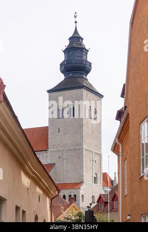 A historic walled town with a church tower sits above a horseshoe river ...