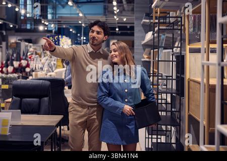 A couple is happily exploring a furniture store together, enjoying the ...