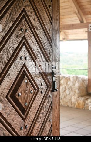 Rustic wooden door with iron studs in stone historical building facade ...