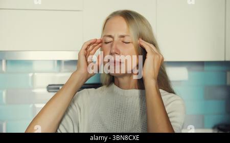 Mature woman suffering from loud neighbour with drill at home Stock ...