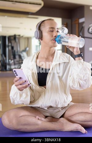 Non-binary Asian person exercising in gym wearing sportswear Stock ...