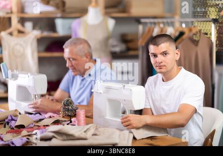 Two male workers in the atelier sewing Stock Photo - Alamy