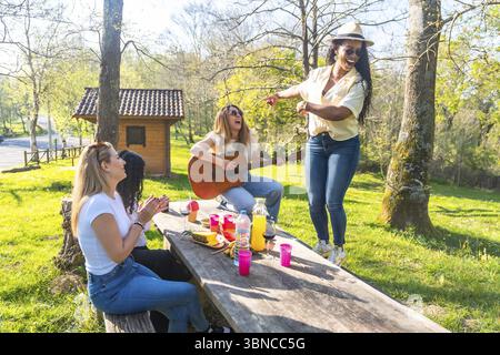Young hispanic woman musician singing song playing classical guitar at ...