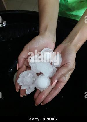 Large ice hail in female hands Stock Photo - Alamy