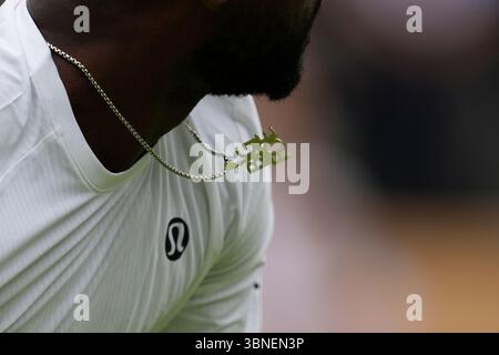 The neck chain of Frances Tiafoe during the match against Cameron ...