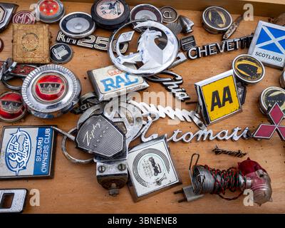A collection of rescued repurposed classic car badges on a wooden tray ...