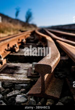 A low angle shot of rusty metal pole into old weathered wooden fence ...