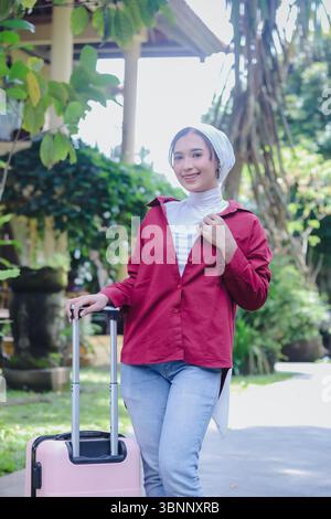 Stylish Muslim woman wearing casual outfit with hijab watering house ...