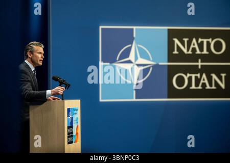 Defense Secretary Pete Hegseth speaks as President Donald Trump, seated ...