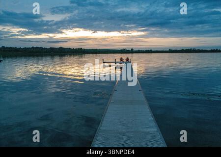 Pier in an inlet of a lake at sunset Stock Photo - Alamy