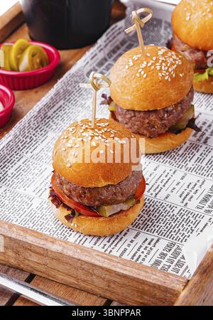 Close up of homemade mini burgers with stew beef, tomatoes and basil on ...