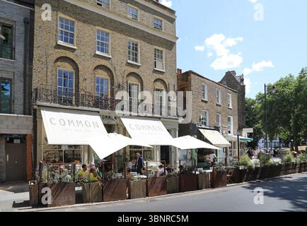 Clapham, London, UK. Open-air tables at restaurants on The Pavement, a ...