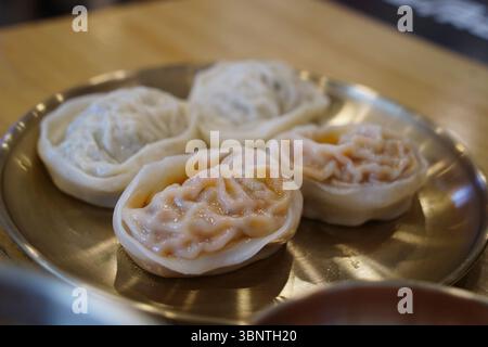 Steamed Korean kimchi dumplings Mandu on green rectangular plate with ...