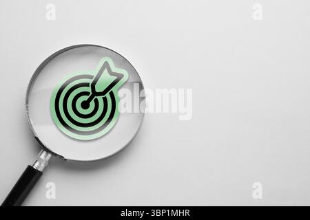 Magnifying glass over target with arrow on green background, top view ...