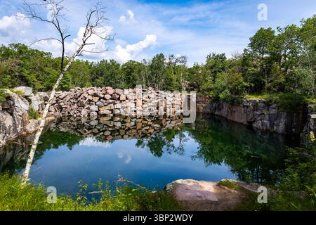 A scenic pond surrounded by rugged rocky stones at Quarry Park and ...