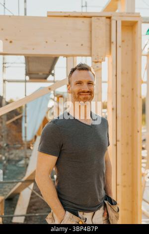 Middle aged casual carpenter in cap and gloves heating metal part with ...
