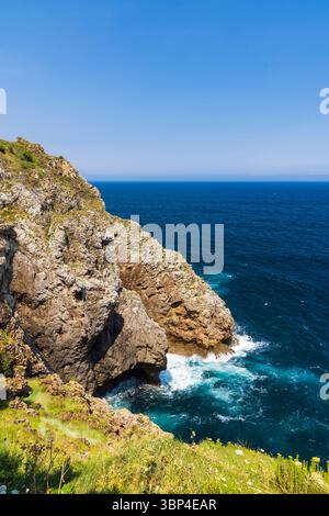 Coastal cliffs meet the ocean under a twilight sky, creating a serene ...