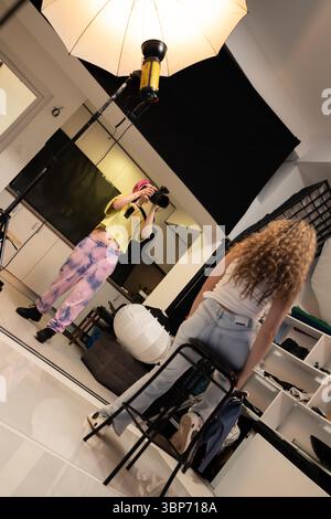 Indoor studio photoshoot featuring a photographer capturing a model's ...