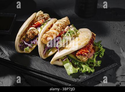 Delicious bao buns with crispy chicken and fresh vegetables Stock Photo ...