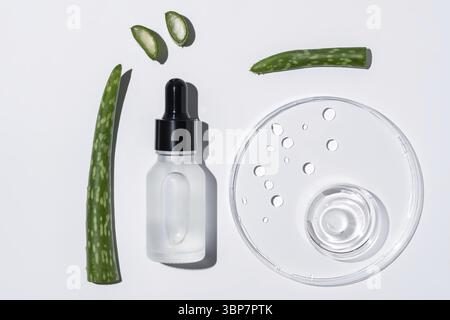 Glass bottle of aloe vera gel with plant leaf pieces on wooden ...