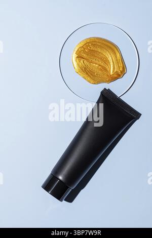 Mockup of black squeeze bottle cosmetic tube and birch small leaves on ...