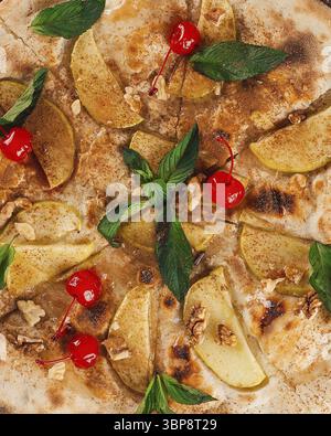 Sweet delicious pizza with apple, cinnamon, chocolate on black ...