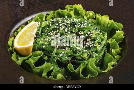 Healthy vegan seaweed salad with lemon and sesame seeds served on a ...