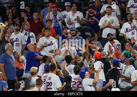 Fans in the stands reach for a foul ball during the second inning of a ...