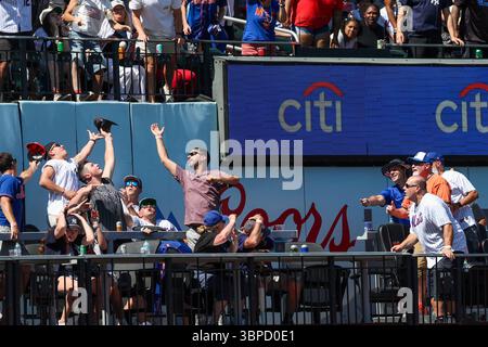 Fans in the stands reach to catch a foul ball during the seventh inning ...