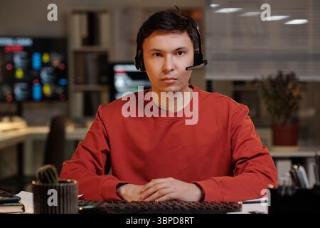 Young asian man looking directly at camera with neutral expression ...