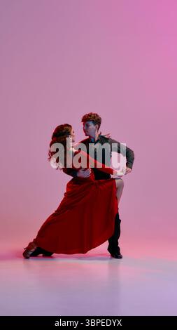 Argentine tango dancers striking dramatic pose on pink gradient ...