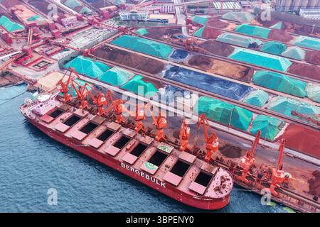 A cargo ship is unloading imported iron ore at the ore terminal of ...