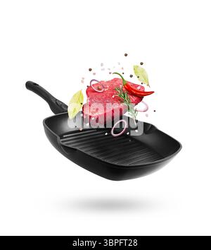 Beef meat flying from a pan with spice and pepper, isolated on white ...