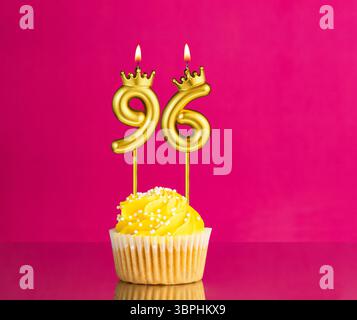 Number 96 gold celebration candle and small stars in sweet cupcake on ...